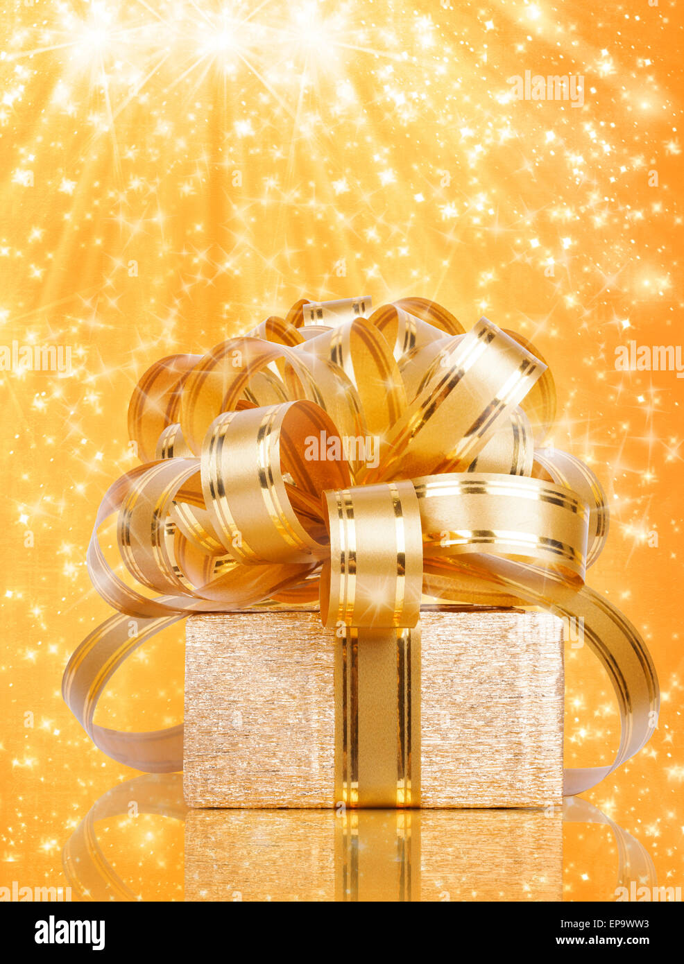 Gift box in gold wrapping paper on a beautiful abstract background ...