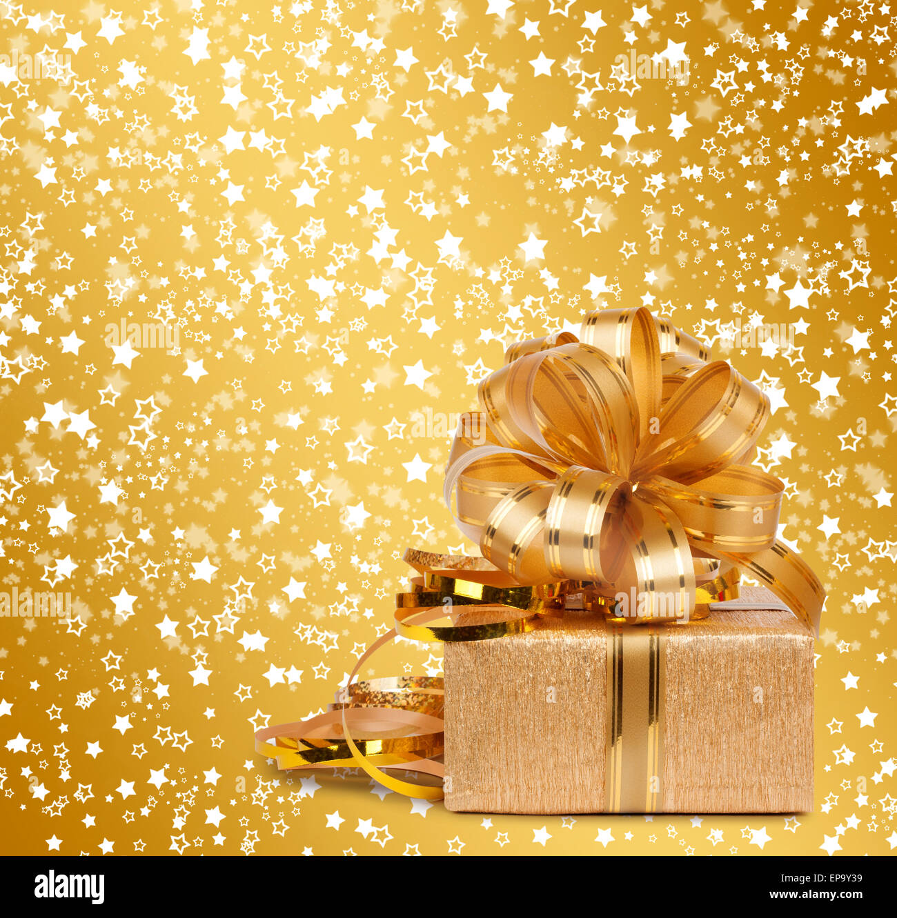 Gift box in gold wrapping paper on a beautiful abstract background ...