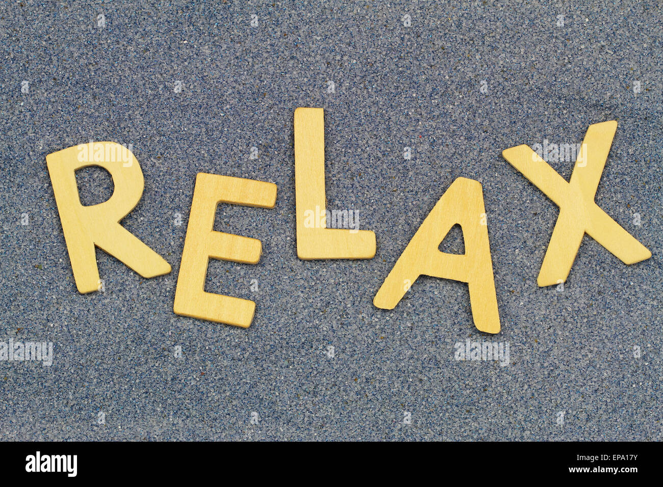 Relax written with wooden letters on blue sand Stock Photo - Alamy