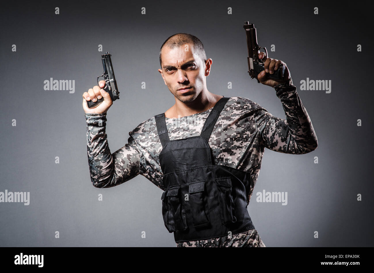 Soldier with guns against dark background Stock Photo - Alamy