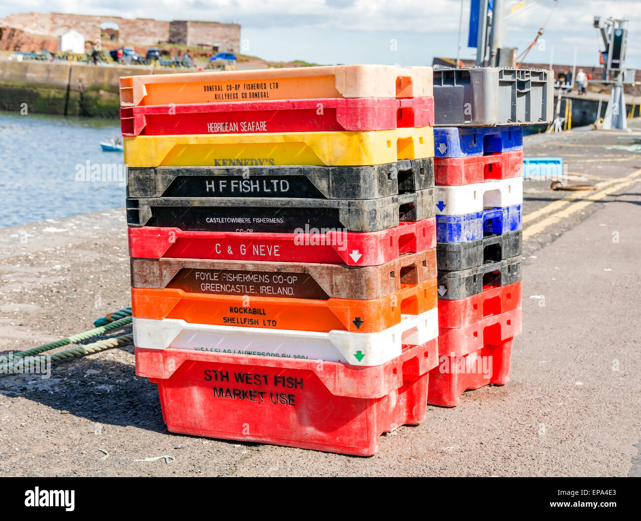 Crates for fish stacked on the quayside ready for boats to land their ...