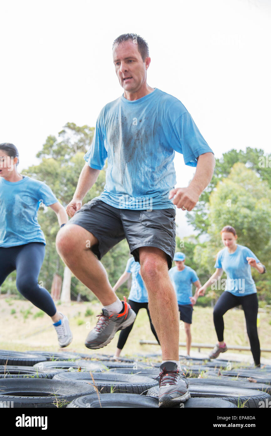 man jumping tire boot camp obstacle course Stock Photo - Alamy
