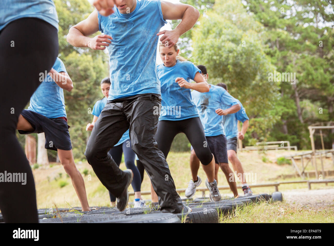 people jumping tire boot camp obstacle course Stock Photo - Alamy
