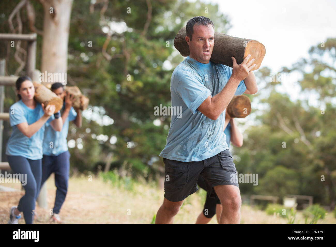 man running log boot camp obstacle course Stock Photo - Alamy