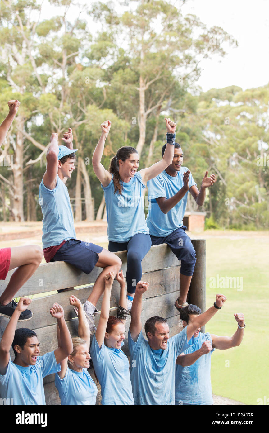 team cheering wall boot camp obstacle course Stock Photo - Alamy