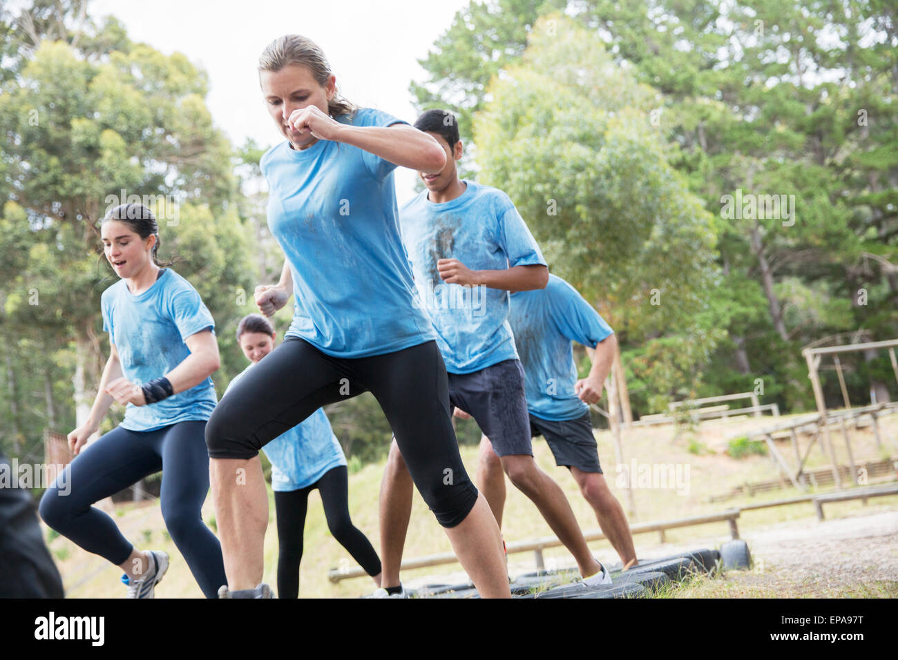 people jumping tire boot camp obstacle course Stock Photo - Alamy