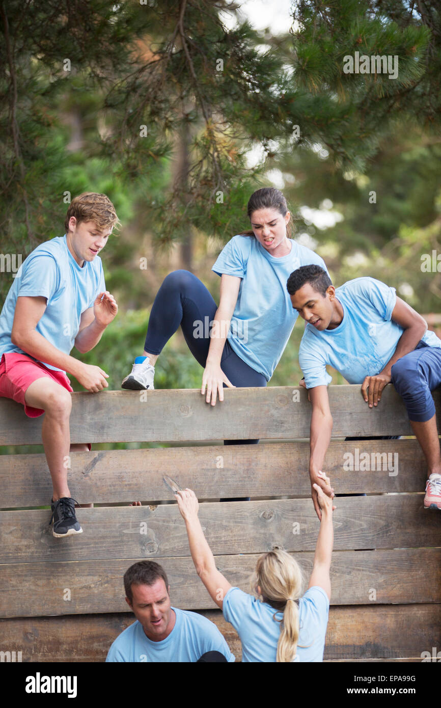 helping woman wall boot camp obstacle course Stock Photo - Alamy