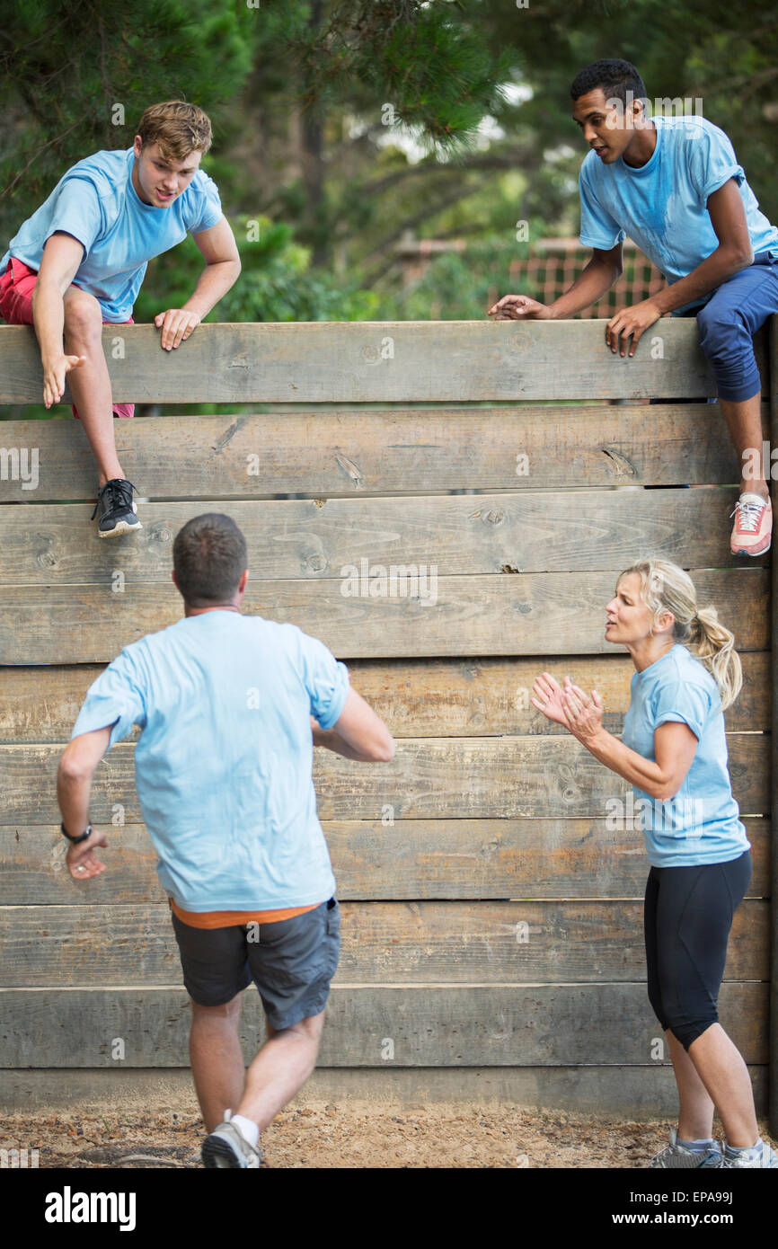 cheering man wall boot camp obstacle course Stock Photo - Alamy