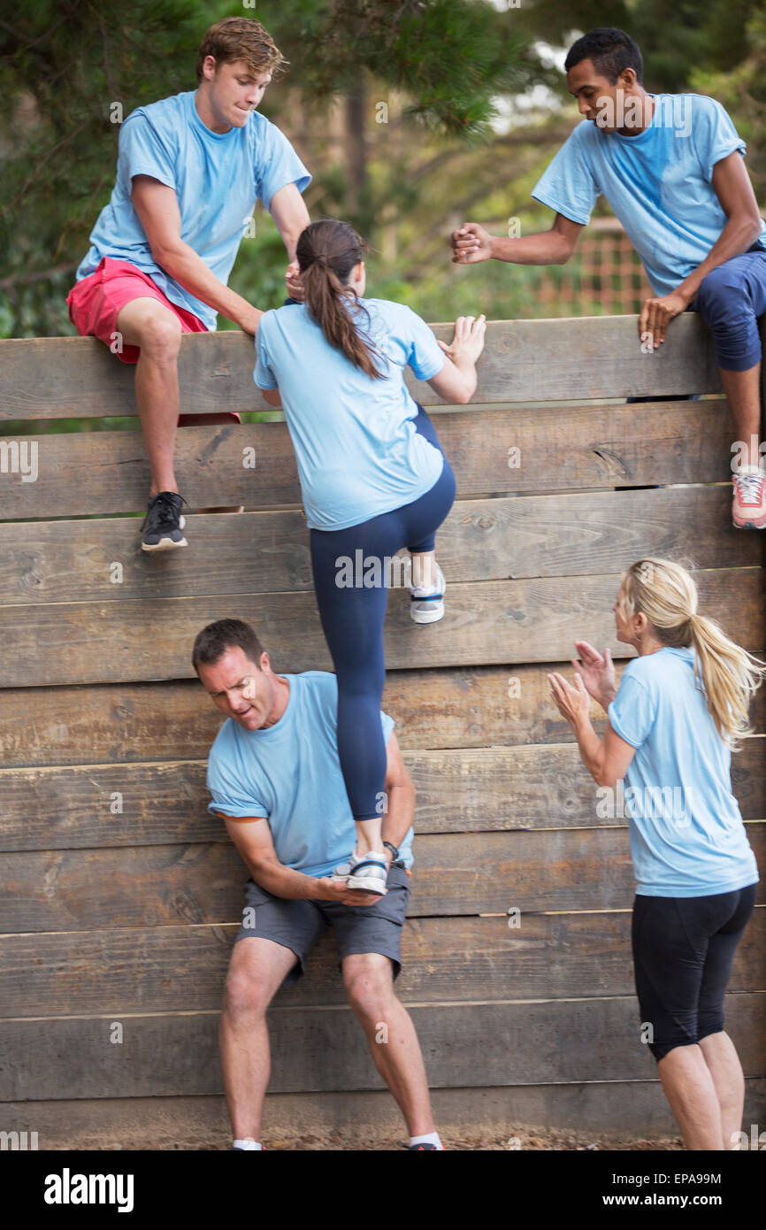 helping woman wall boot camp obstacle course Stock Photo - Alamy