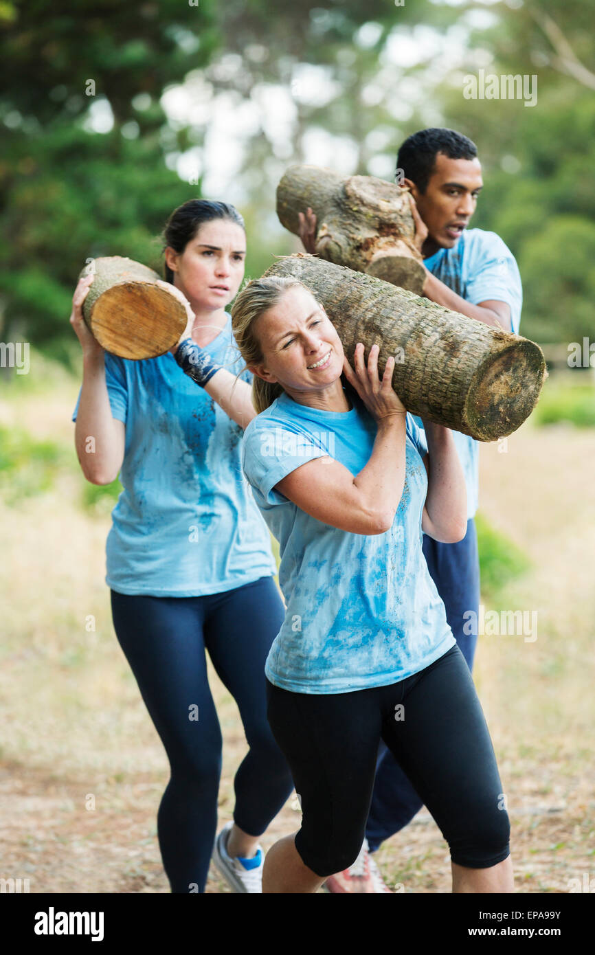 woman running log boot camp obstacle course Stock Photo - Alamy