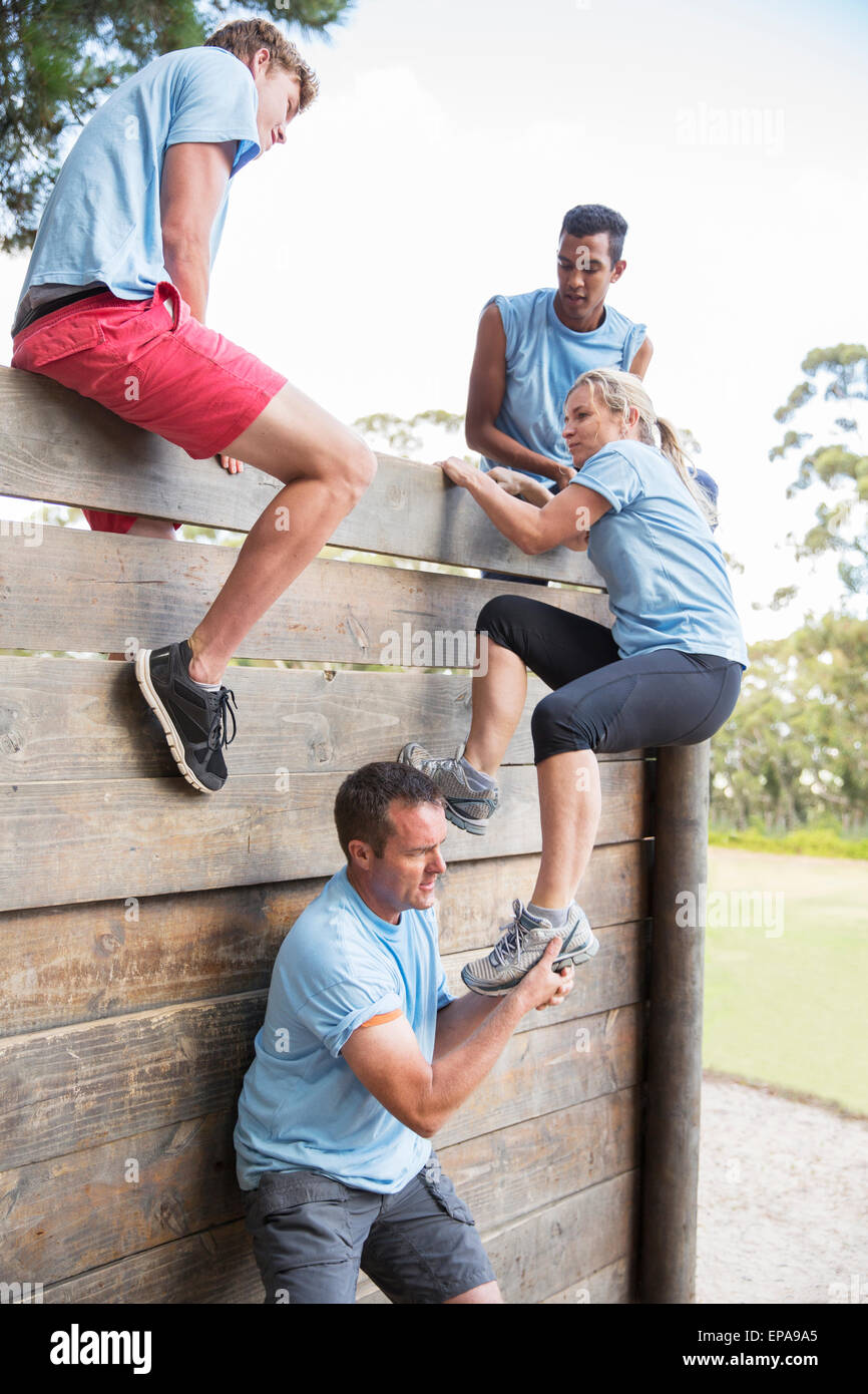 helping woman wall boot camp obstacle course Stock Photo - Alamy