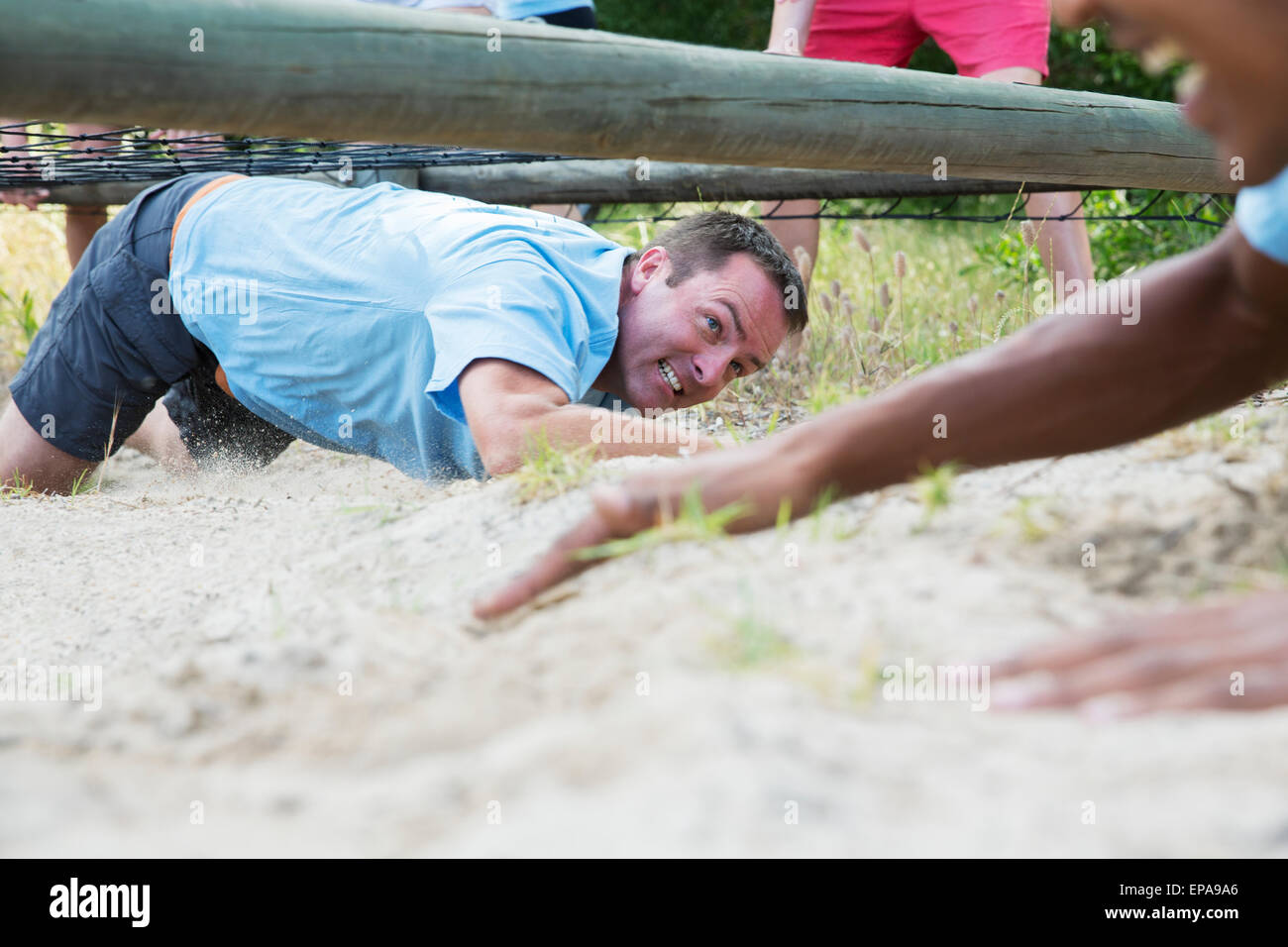 man crawling net boot camp obstacle course Stock Photo - Alamy