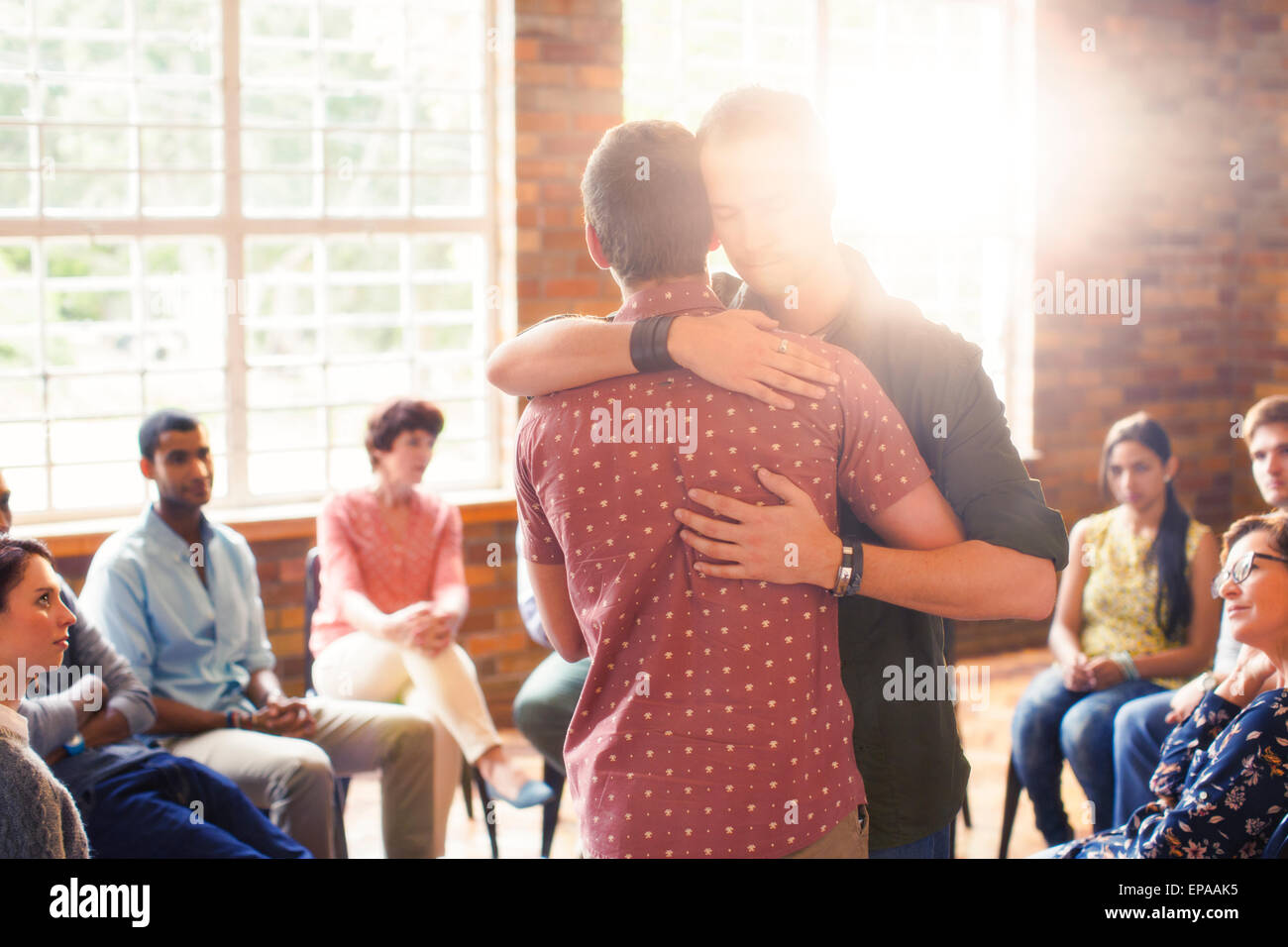 man hugging group therapy session Stock Photo - Alamy