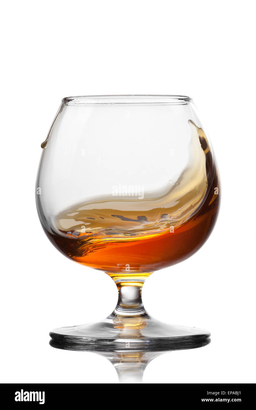 Splash of cognac in glass isolated on white background Stock Photo - Alamy