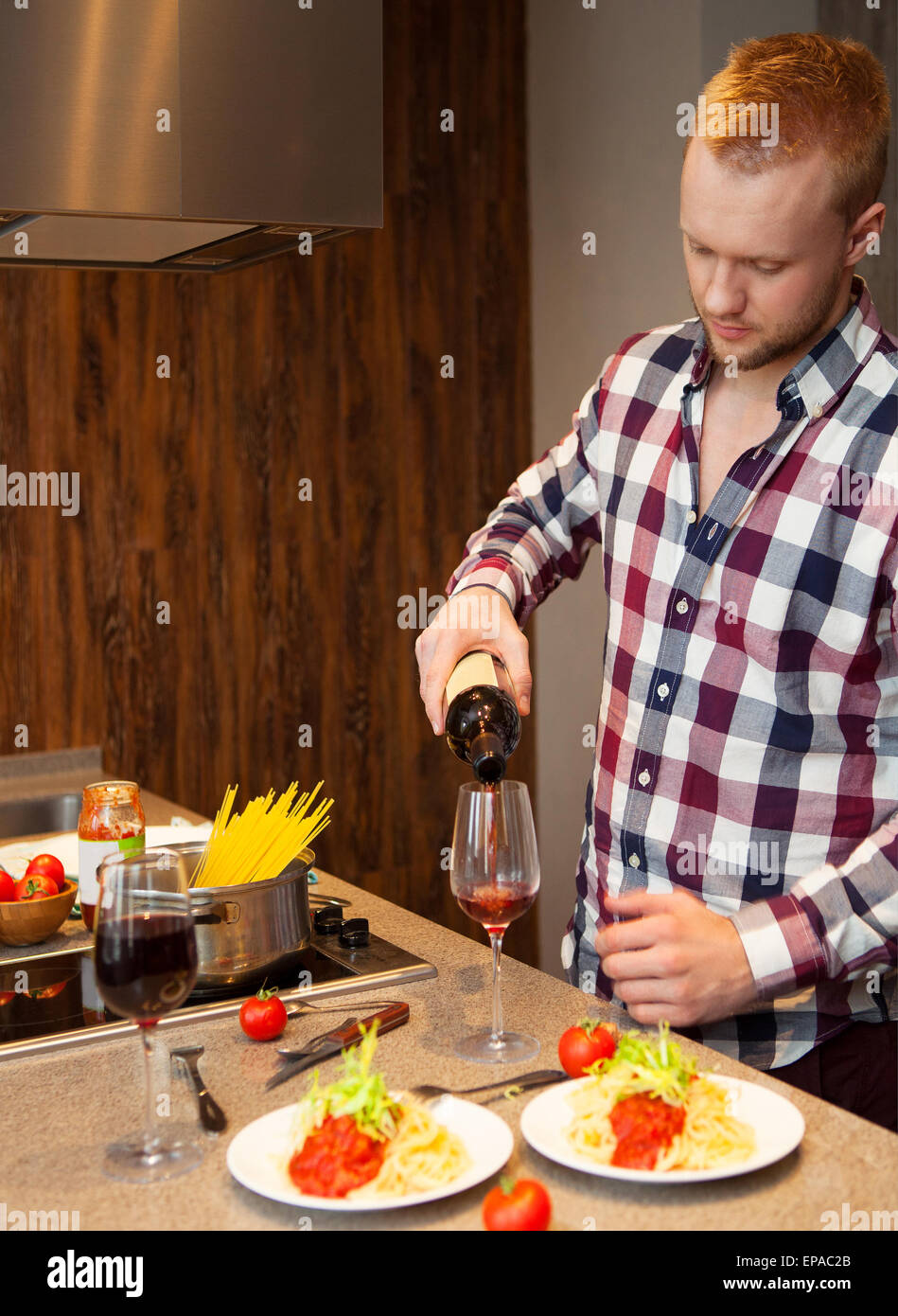 Handsome man cooking at home preparing pasta Stock Photo - Alamy
