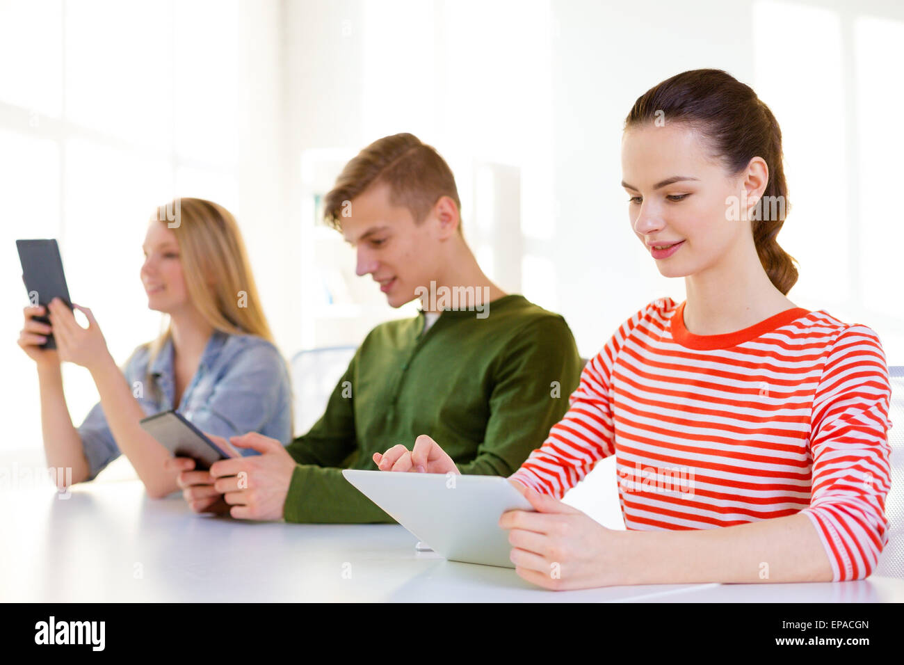 smiling students with tablet pc at school Stock Photo - Alamy