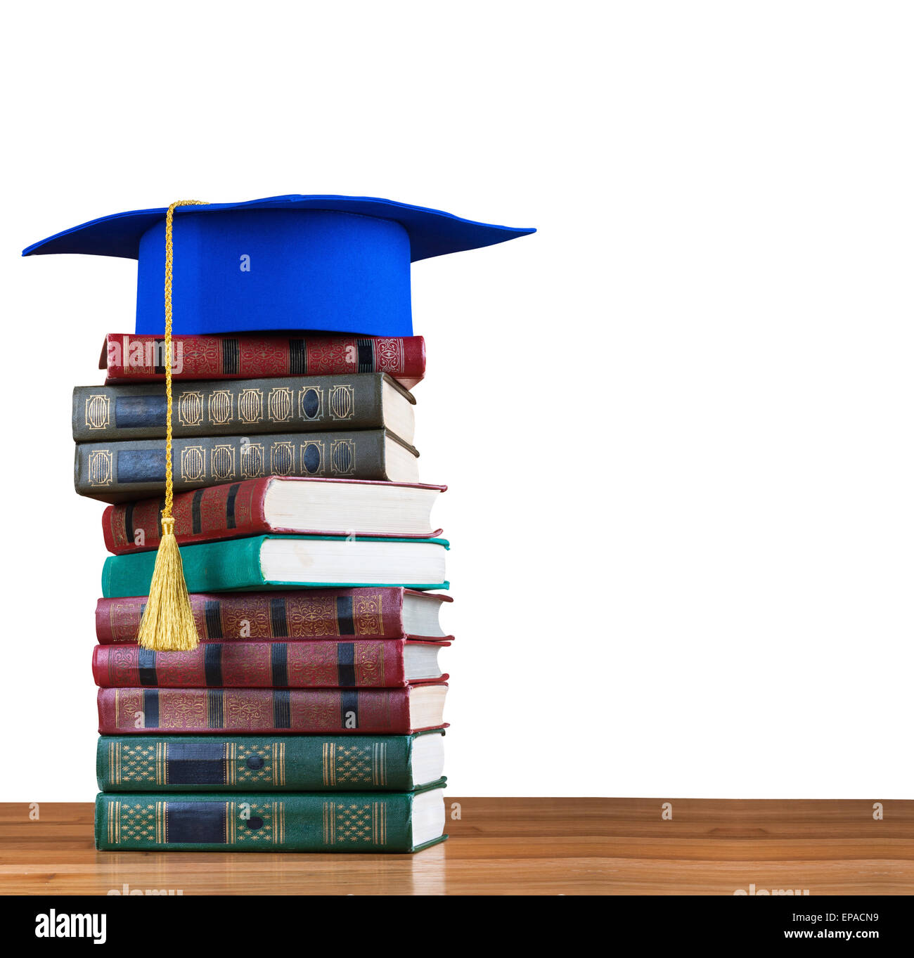 Graduation mortarboard on top of stack of books on abstract background ...