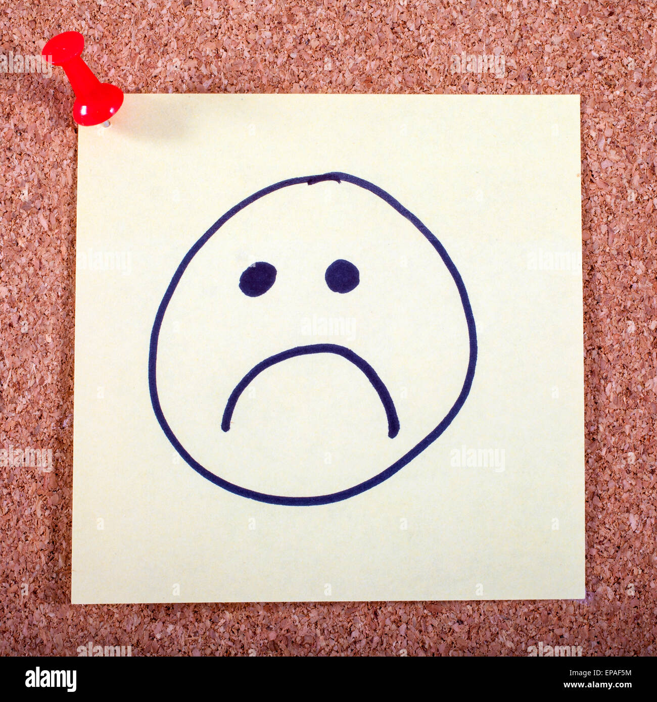 An unhappy face on a piece of Memo Paper Stock Photo - Alamy