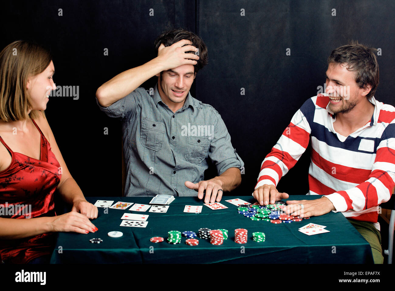 young people playing poker on black background Stock Photo - Alamy