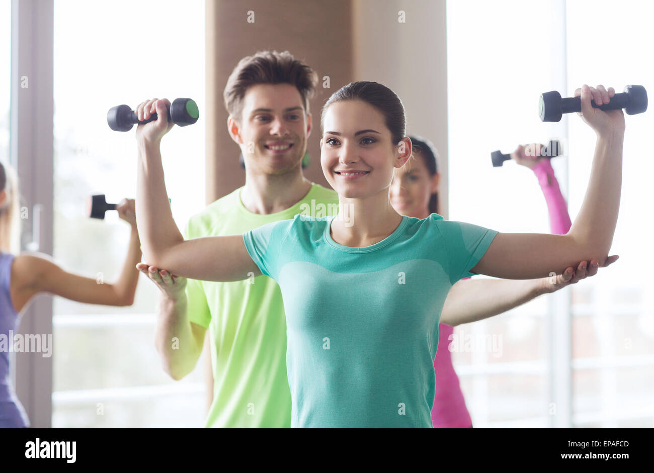 happy women and trainer with dumbbells in gym Stock Photo - Alamy