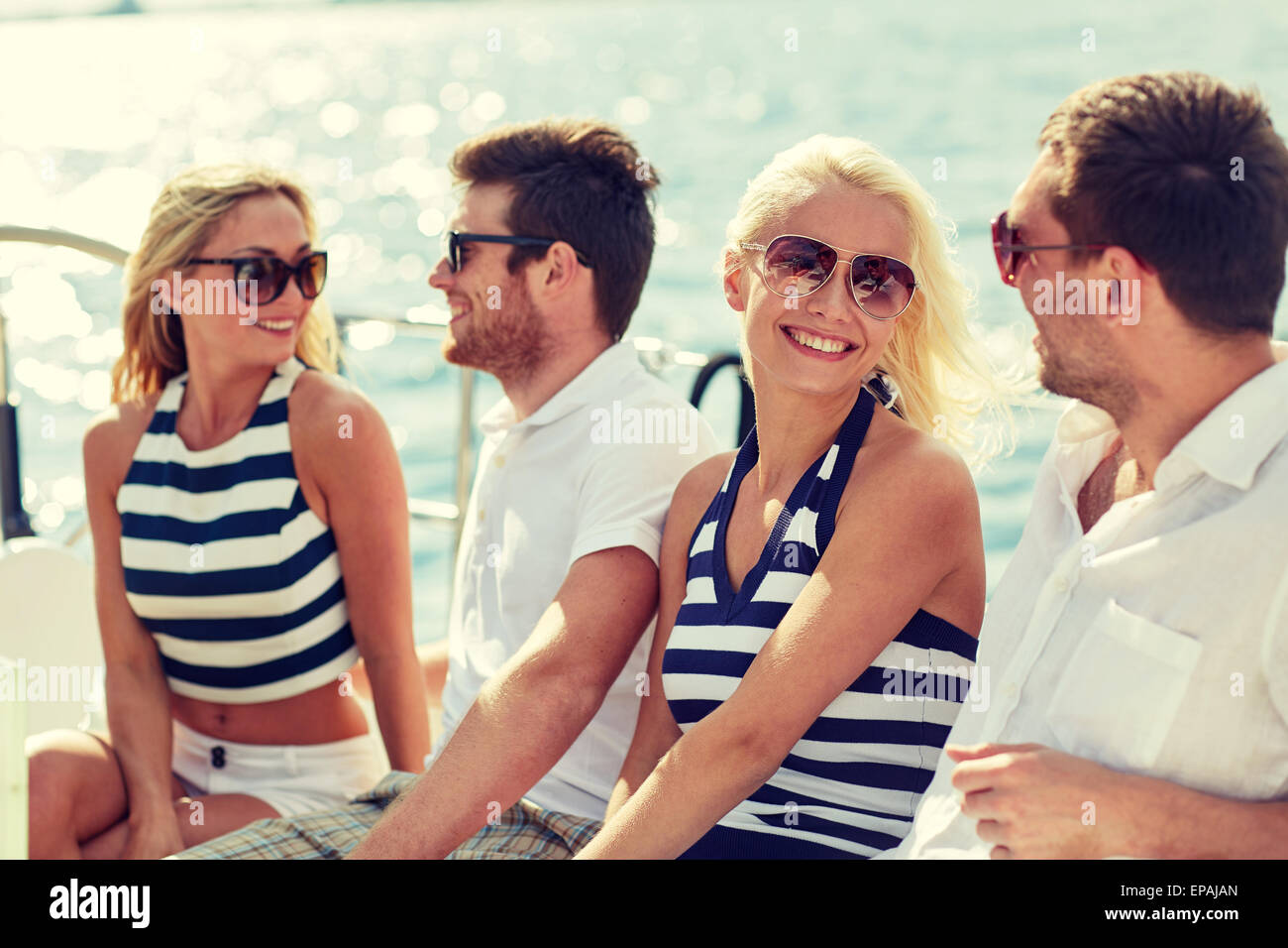 smiling friends sitting on yacht deck Stock Photo - Alamy