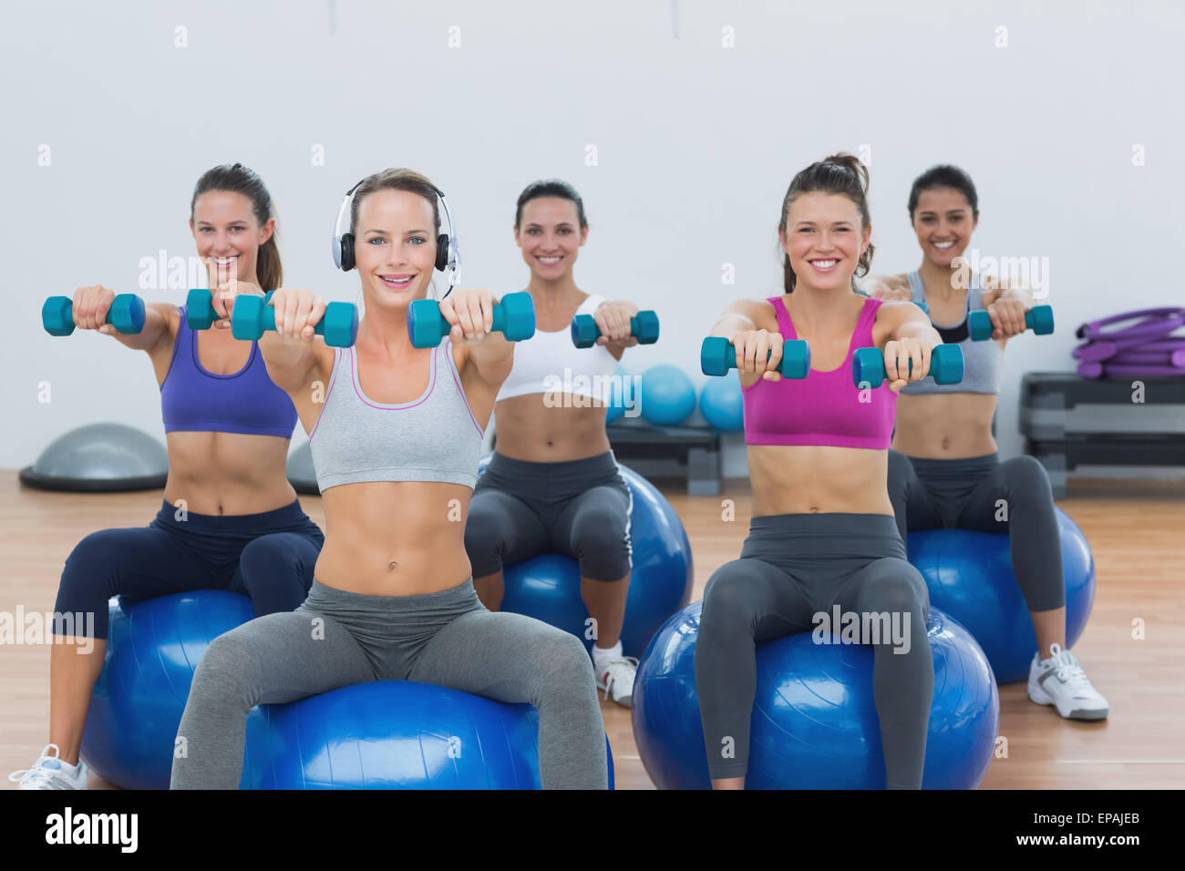 Women exercising with dumbbells on fitness balls Stock Photo - Alamy