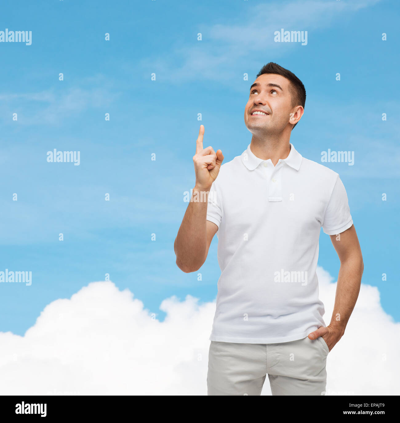 smiling man pointing finger up over blue sky Stock Photo - Alamy