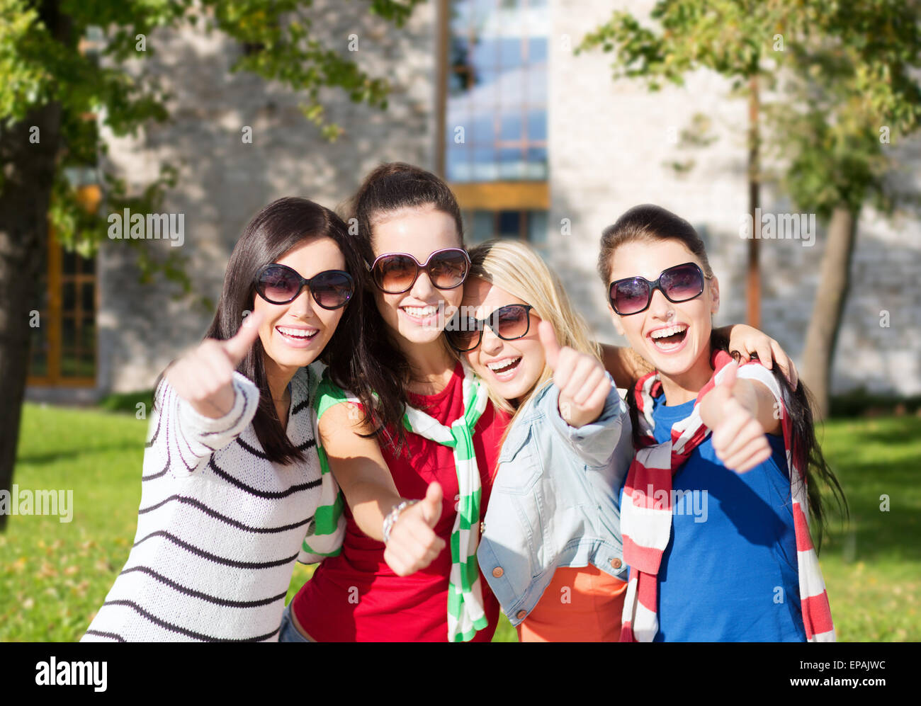happy teenage girls showing thumbs up at campus Stock Photo - Alamy