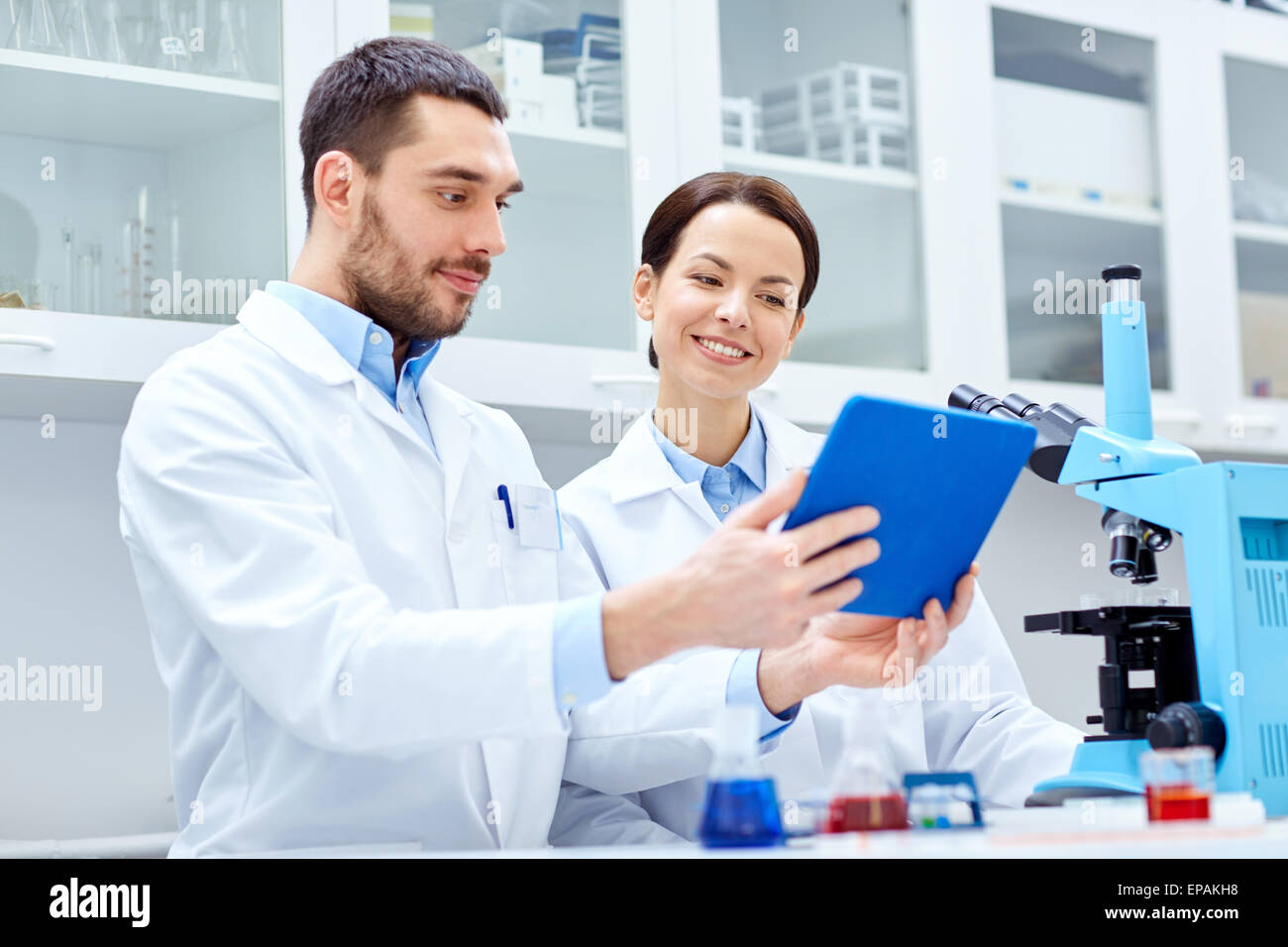 scientists with tablet pc and microscope in lab Stock Photo - Alamy