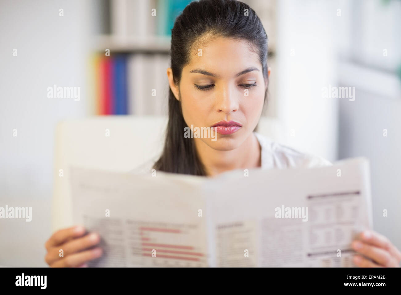 Businesswoman reading newspaper Stock Photo - Alamy