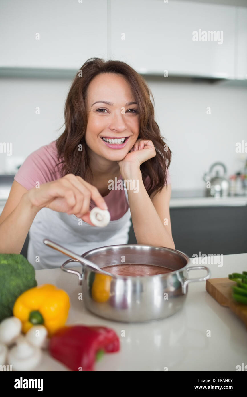 Smiling young woman preparing food in kitchen Stock Photo - Alamy