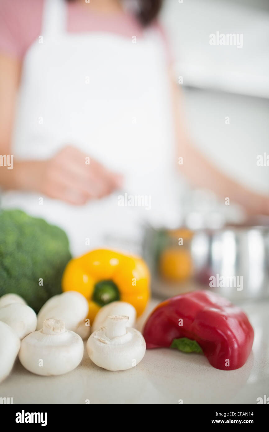 Vegetables with blurred woman preparing food in kitchen Stock Photo - Alamy