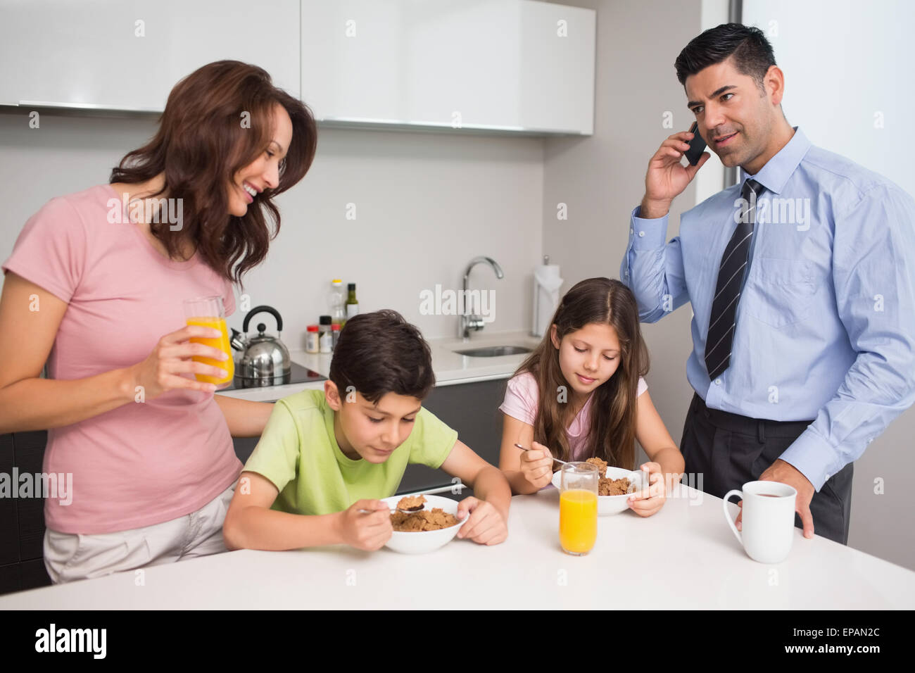 Kids with parents having breakfast in kitchen Stock Photo - Alamy