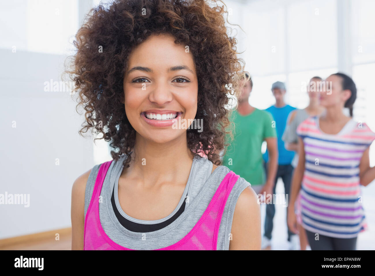 Cheerful instructor with fitness class in background Stock Photo - Alamy