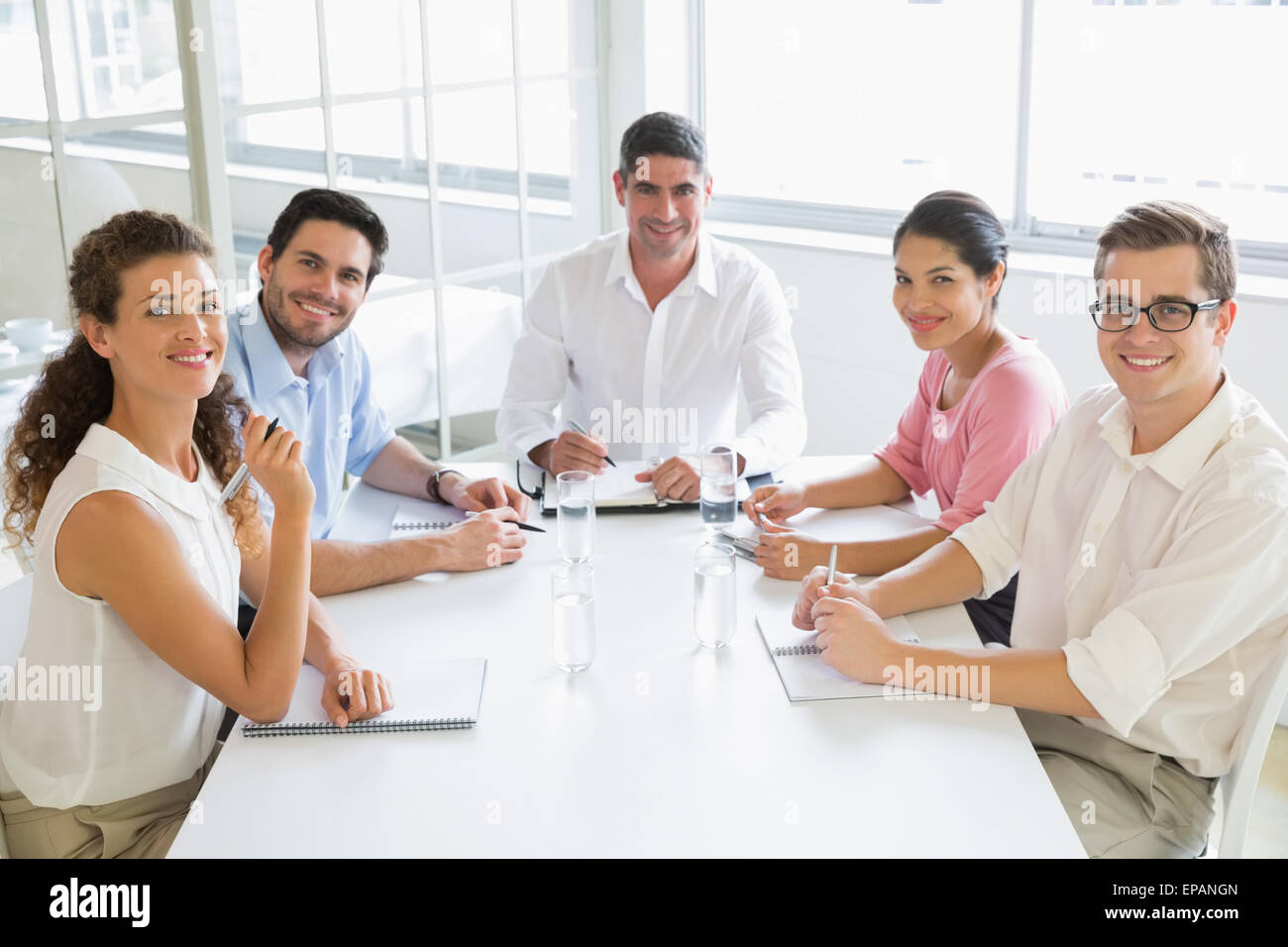 Smiling business people at conference table Stock Photo - Alamy