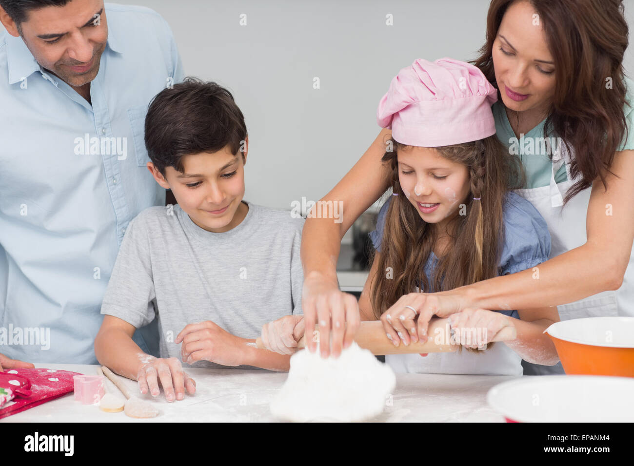 Family of four preparing cookies in the kitchen Stock Photo - Alamy