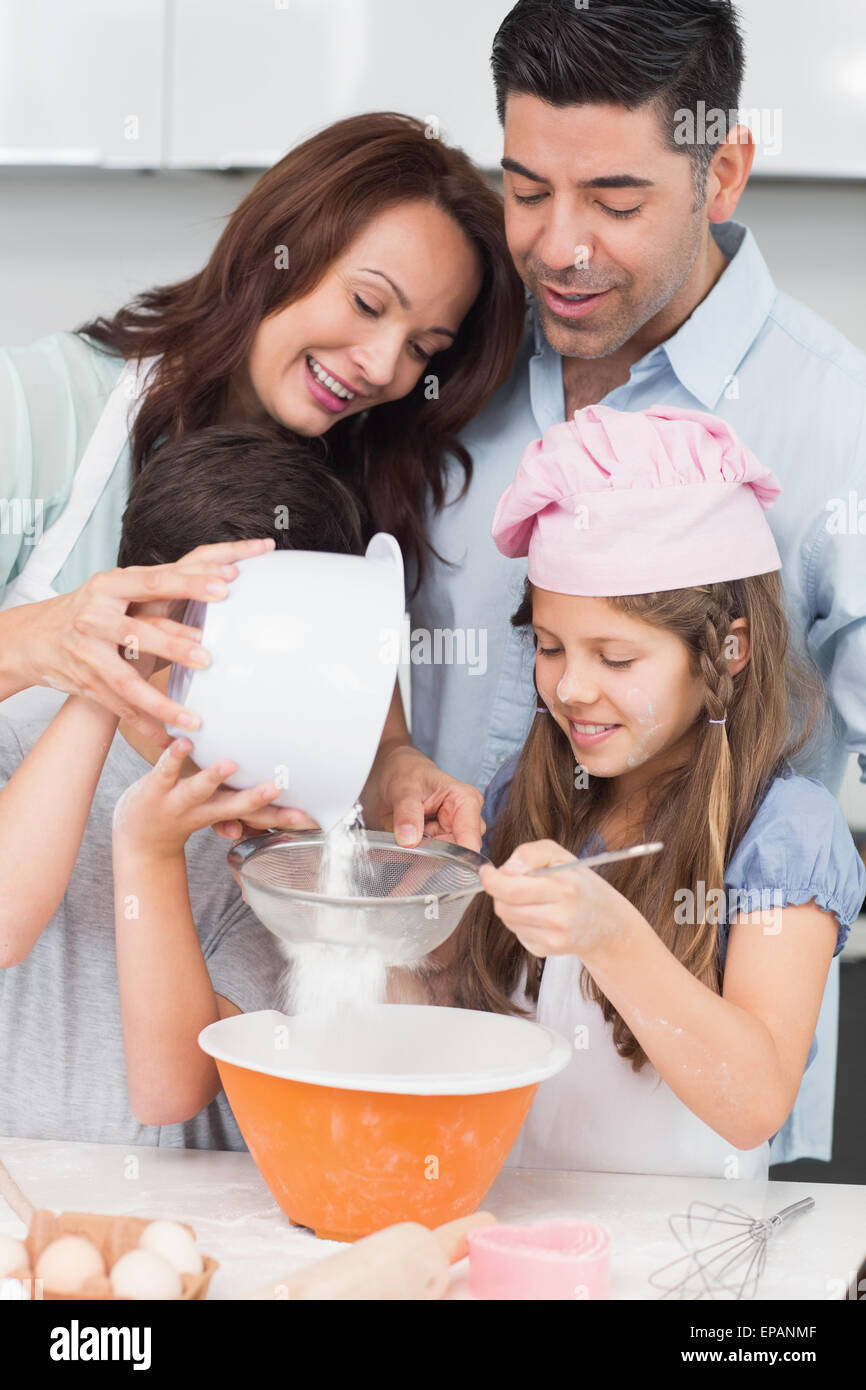 Family of four preparing cookies in the kitchen Stock Photo - Alamy