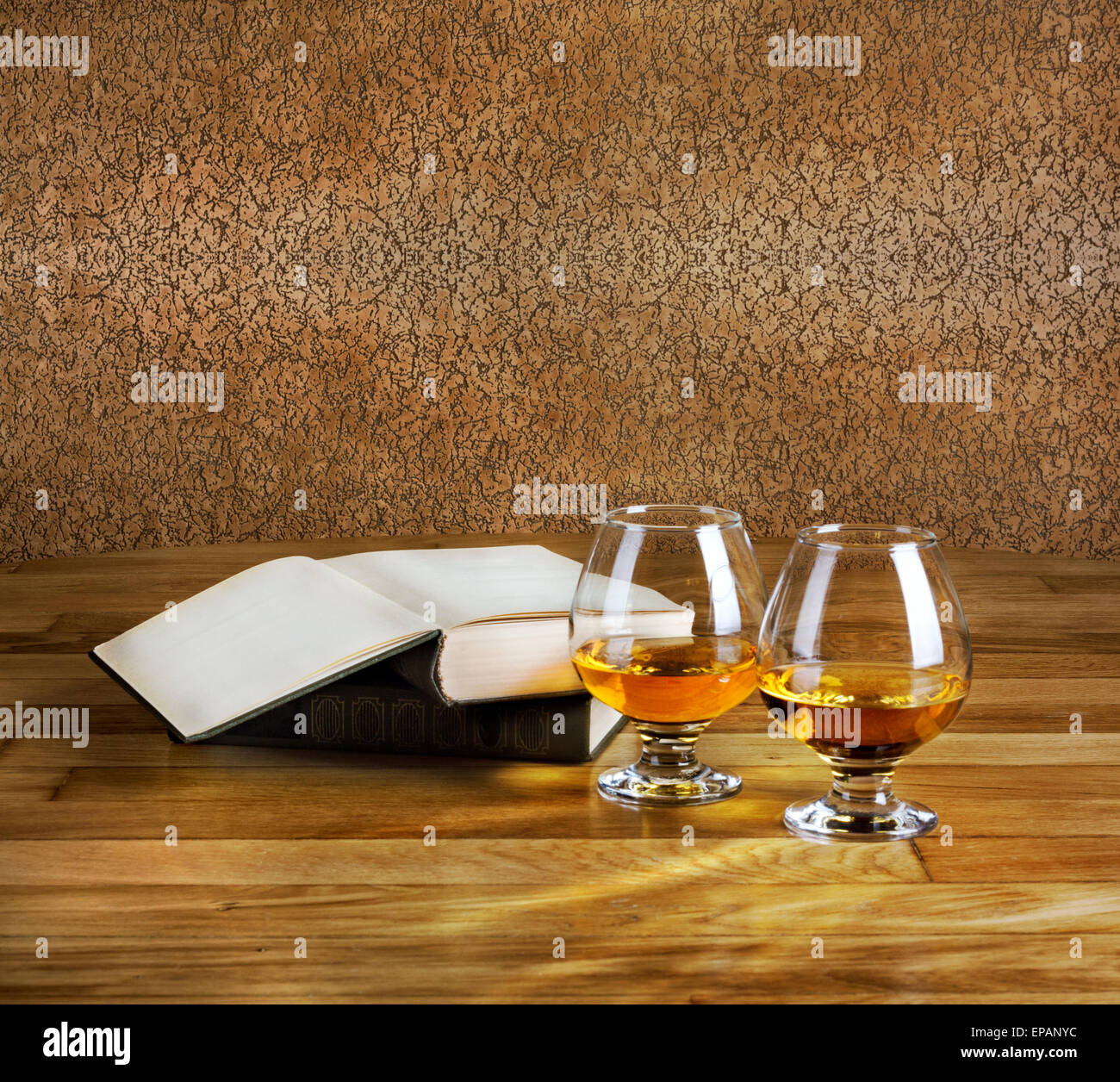 Two goblets of brandy and open book on wooden old counter top Stock ...