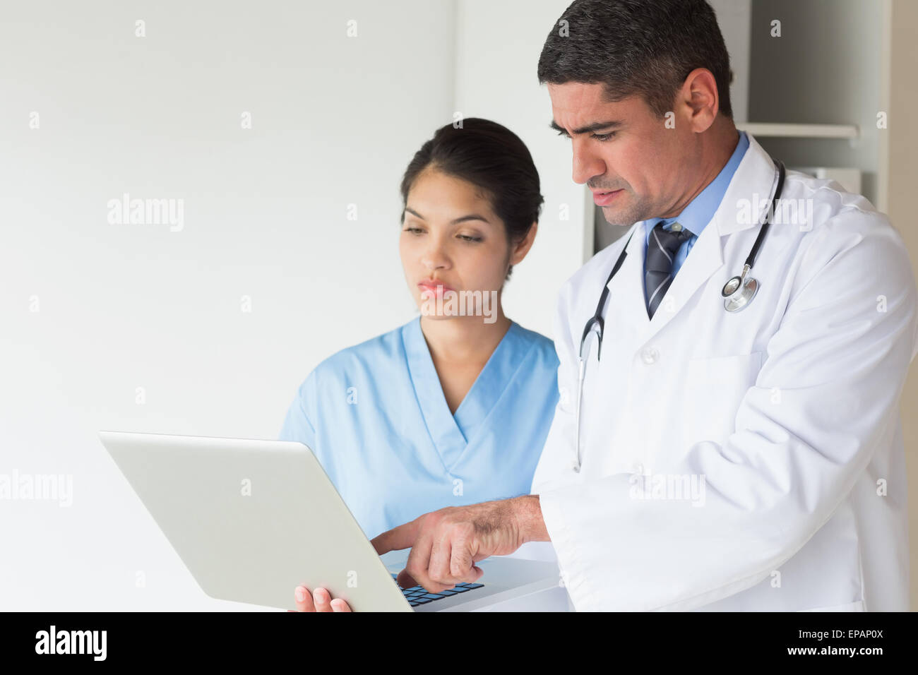 Doctor showing laptop to nurse Stock Photo - Alamy