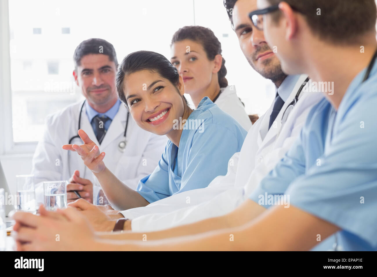 Smiling nurse looking at colleagues Stock Photo - Alamy