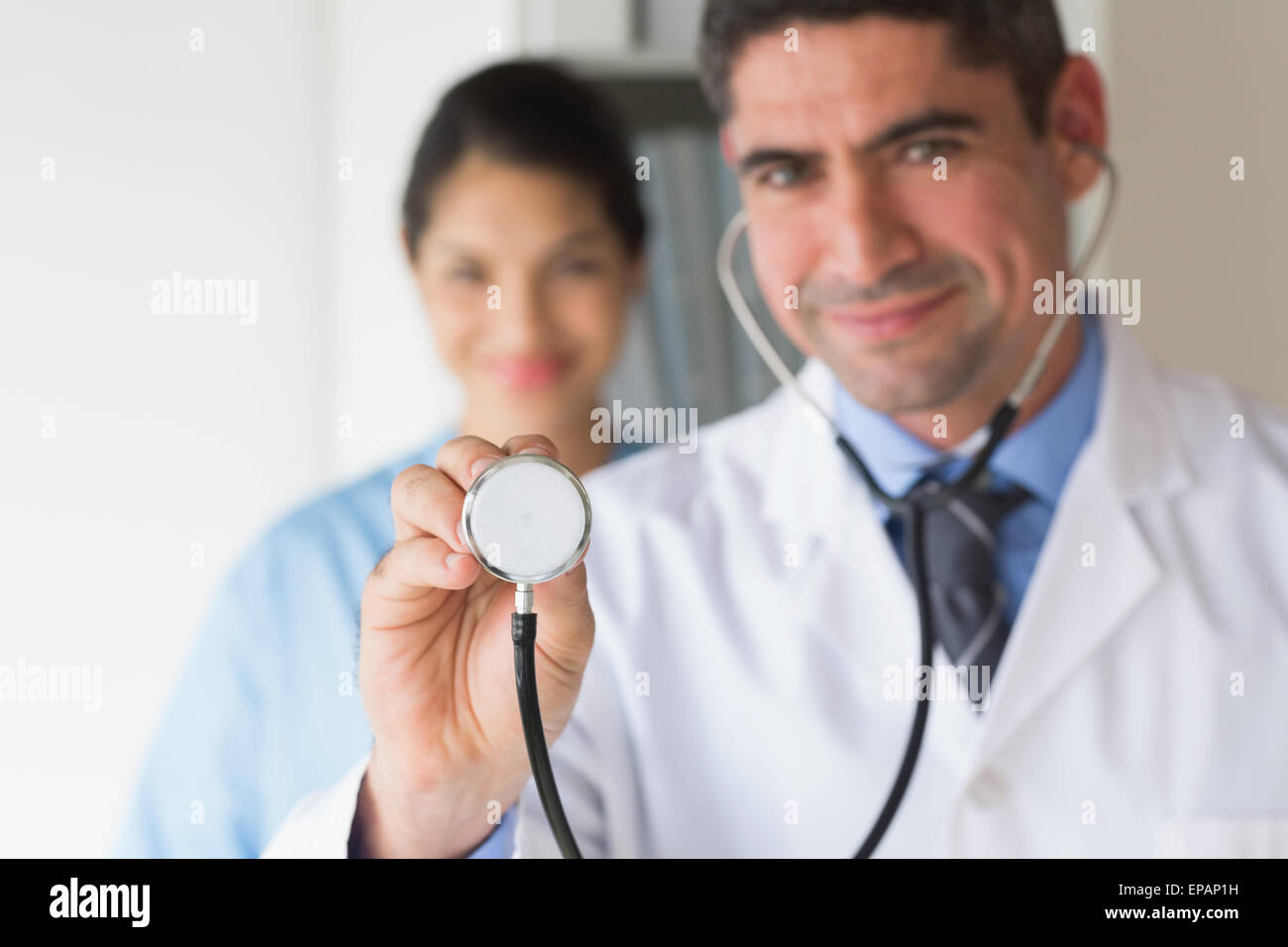 Smiling doctor holding stethoscope Stock Photo - Alamy