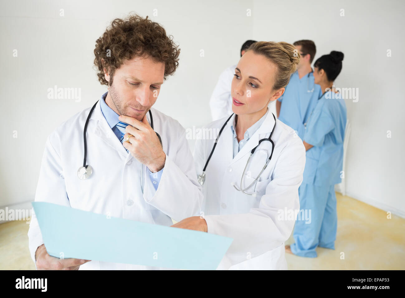 Doctors analyzing file in hospital Stock Photo - Alamy