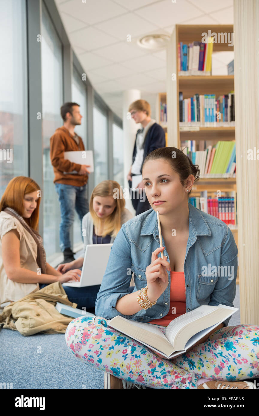 Girl looking outside in college library Stock Photo - Alamy