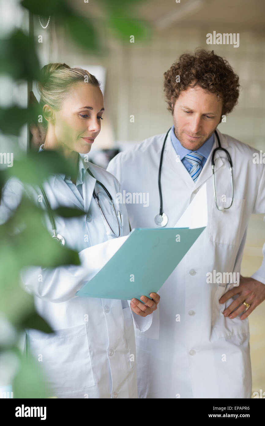 Doctors discussing over file Stock Photo - Alamy