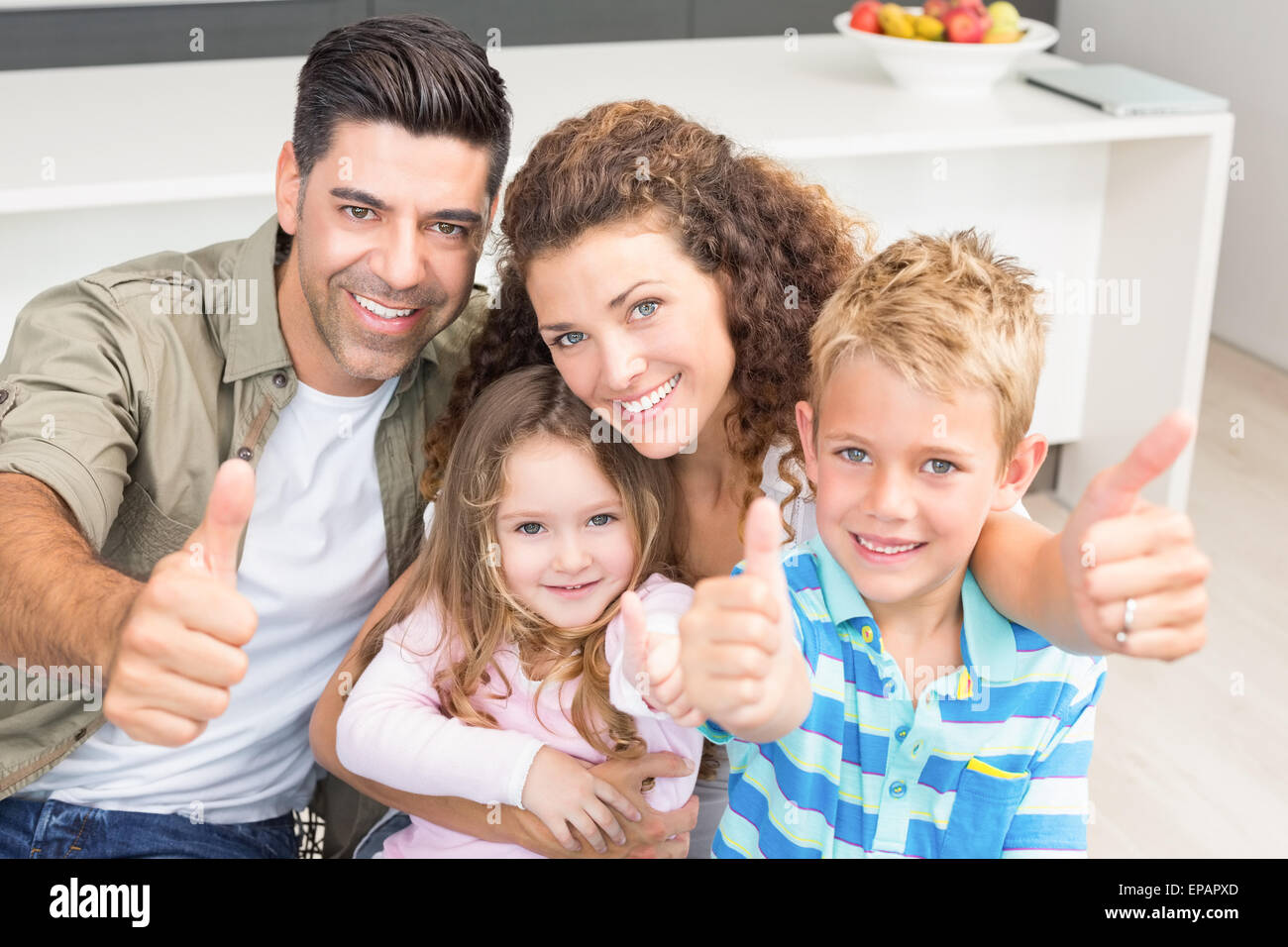 Happy parents giving thumbs up with their young children Stock Photo ...
