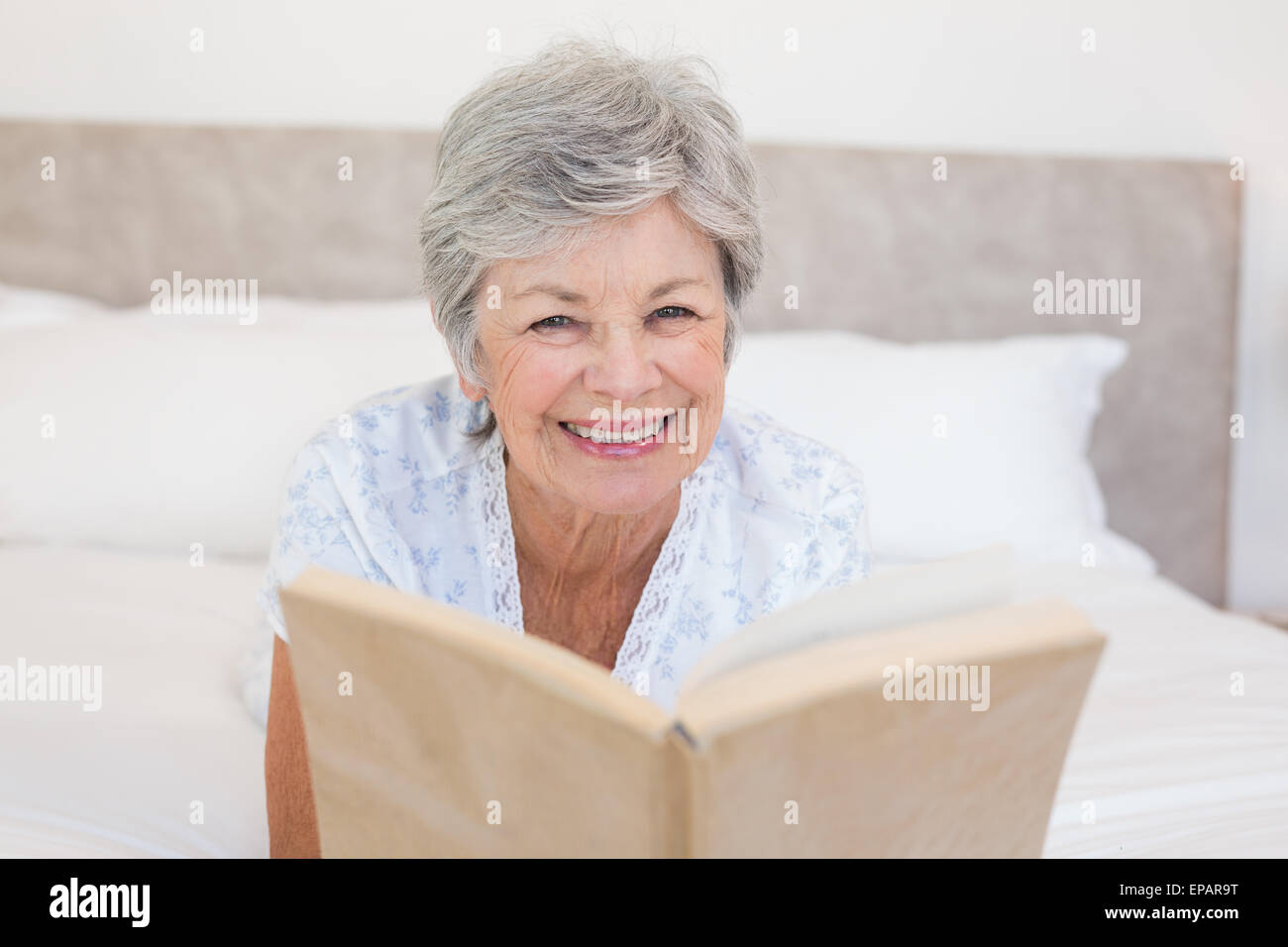 Happy senior woman reading story book Stock Photo - Alamy