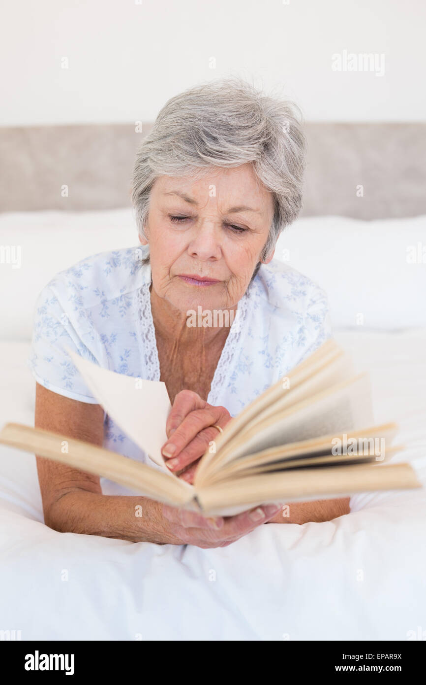 Senior woman reading story book in bed Stock Photo - Alamy