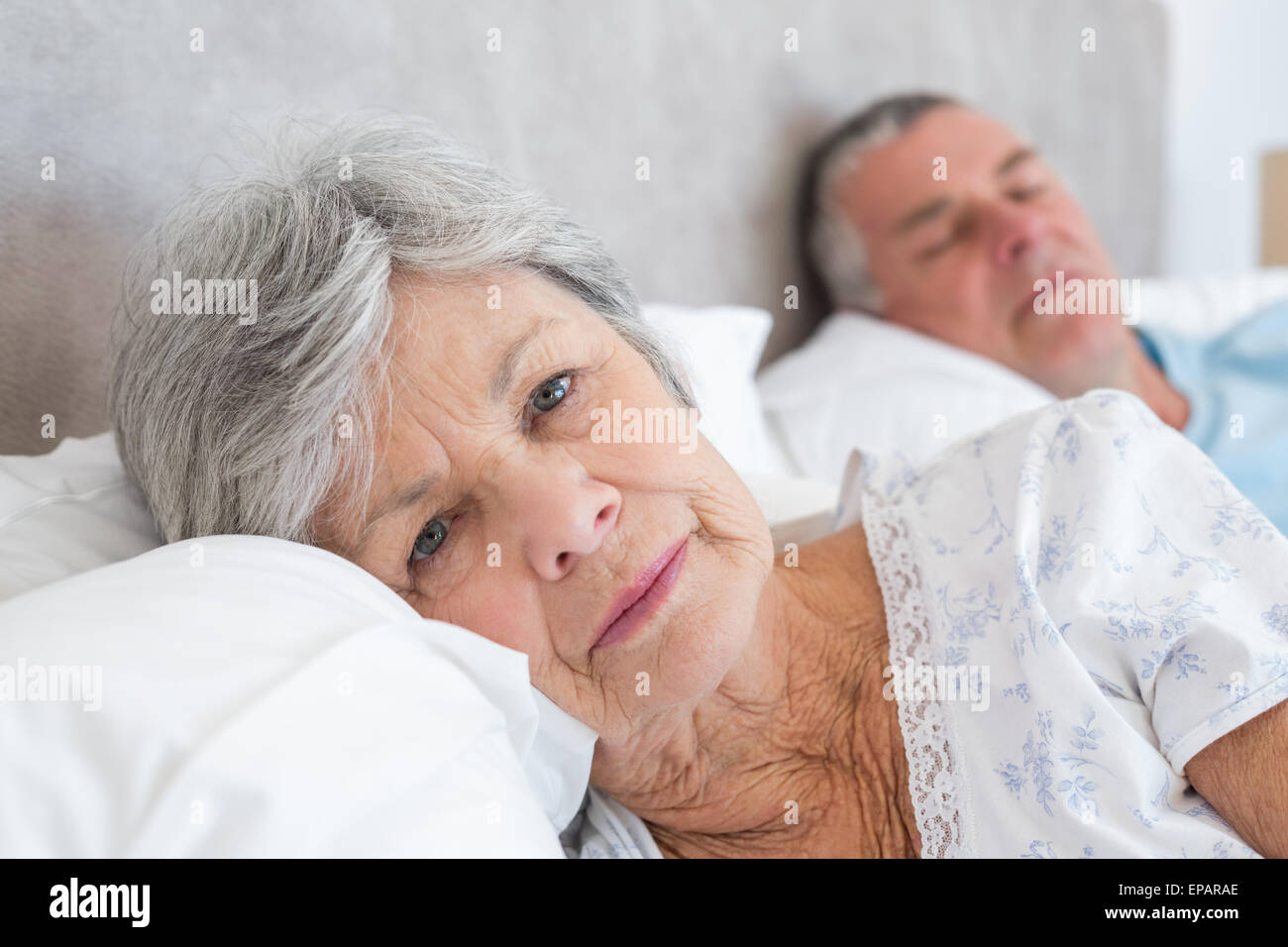 Senior woman lying with man in background Stock Photo - Alamy