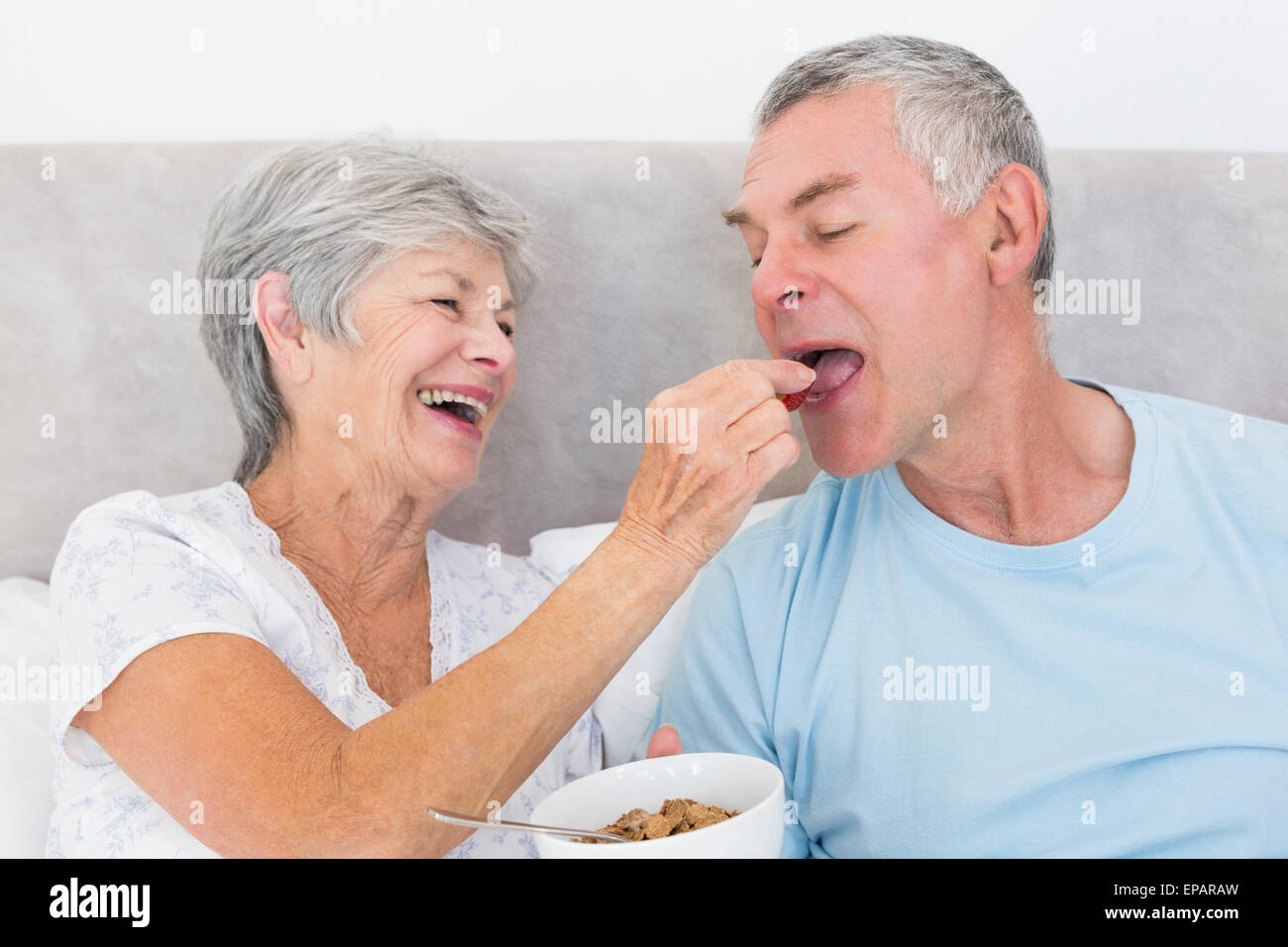 Loving senior woman feeding cereals to husband Stock Photo - Alamy