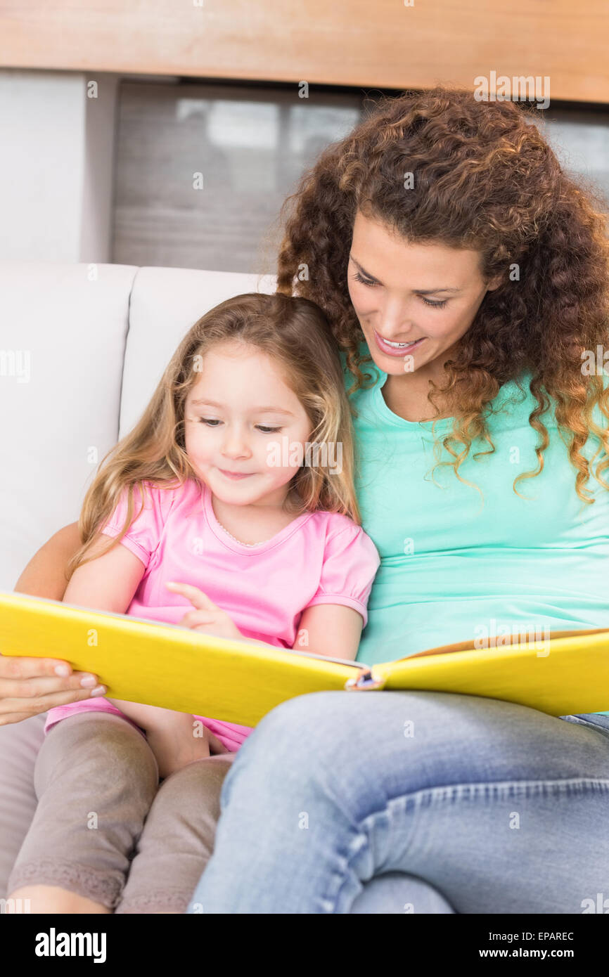 Pretty mother helping her little daughter read a storybook Stock Photo ...